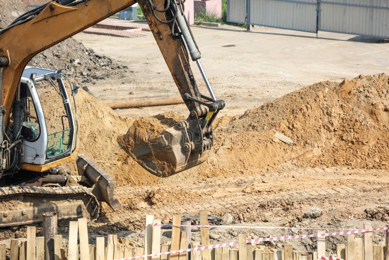 Excavator Digs the Ground at a Construction Site. Stock Photo - Image ...