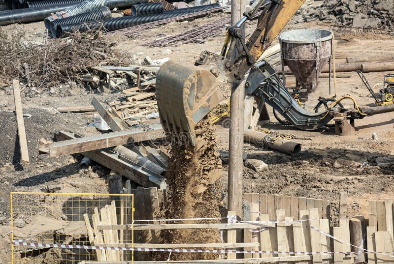 Excavator Digs the Ground at a Construction Site. Stock Photo - Image ...