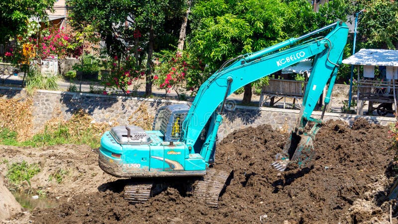 Excavator Driver is Digging Soil in the River To Make the Water Flow ...