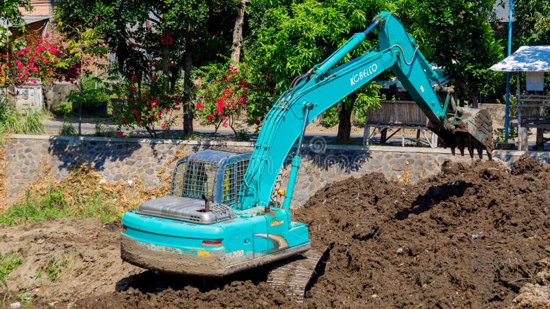 Excavator Driver is Digging Soil in the River To Make the Water Flow ...