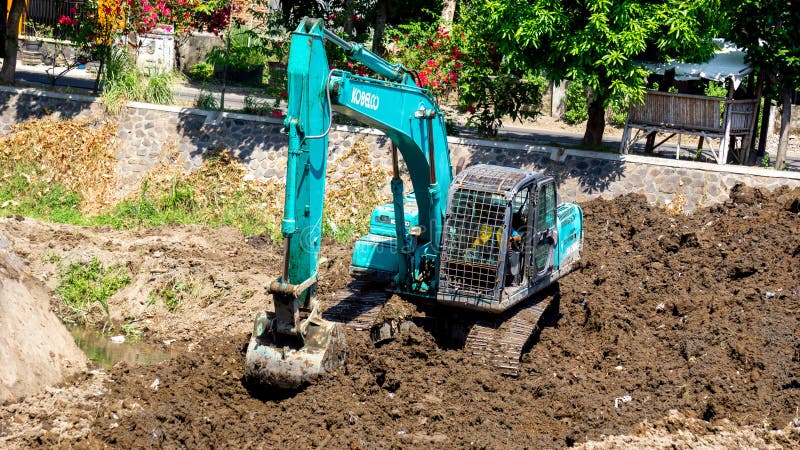 Excavator Driver is Digging Soil in the River To Make the Water Flow ...