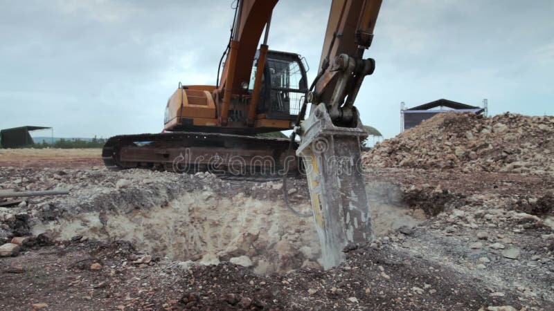 Excavator with Hydraulic Hammer Drill at Work Breaking Down Earth for ...