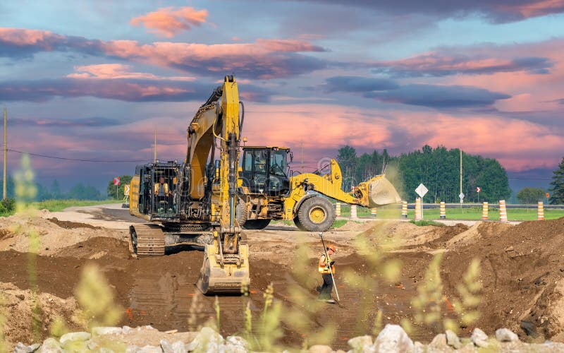 Excavator, Loader and Surveyor Working on a Road Construction Site ...