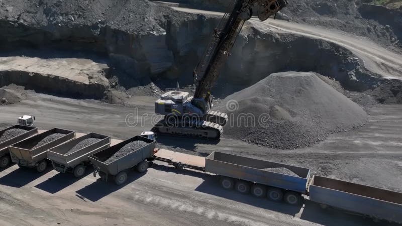 Excavator Loading Coal into Large Dump Trucks in an Open Mining ...