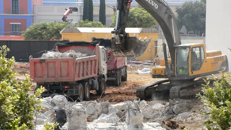 Excavator Loading Debris into a Construction Truck during a Building ...