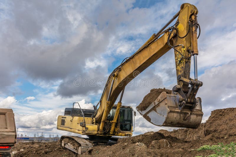 Excavator Loading Earth To Perform Works of Settlement of a Road Stock ...