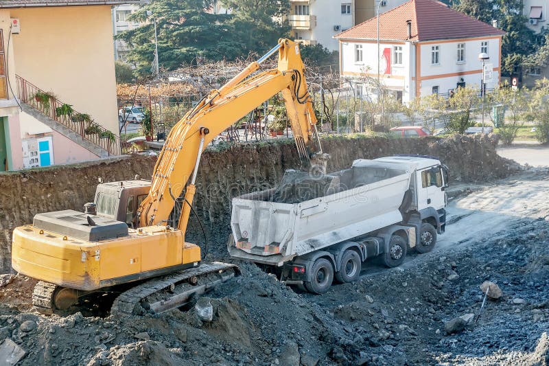 Excavator Loading Earth in the Truck on Construction Site Stock Photo ...