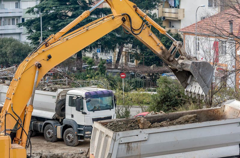 Excavator Loading Earth in the Truck on Construction Site Stock Photo ...