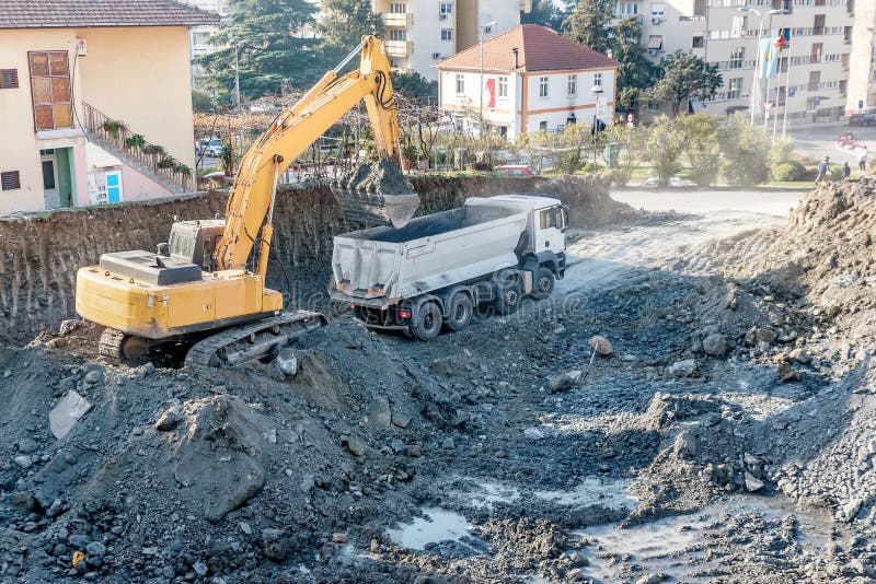 Excavator Loading Earth in the Truck on Construction Site Stock Image ...