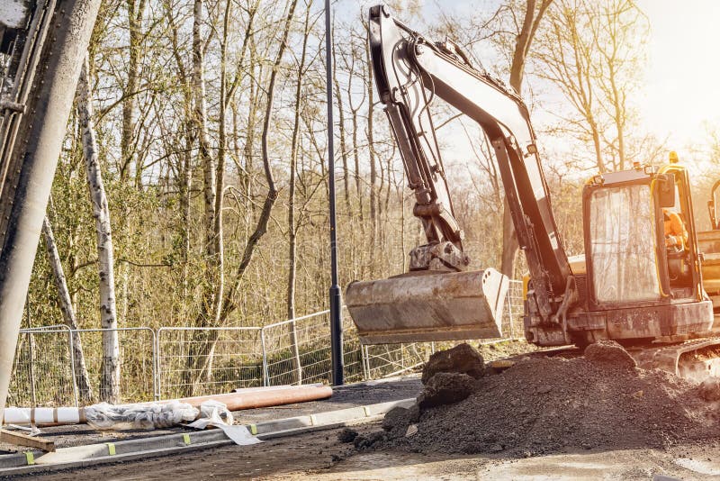 Excavator Loading Semi-dry Concrete Mix into Dumper on Construction ...