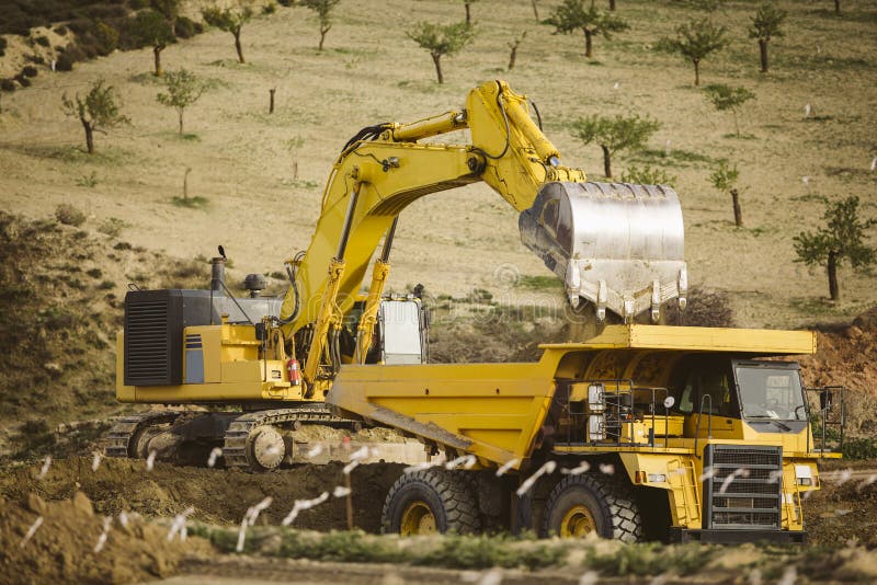 Excavator loading a truck. stock photo. Image of power - 115998168