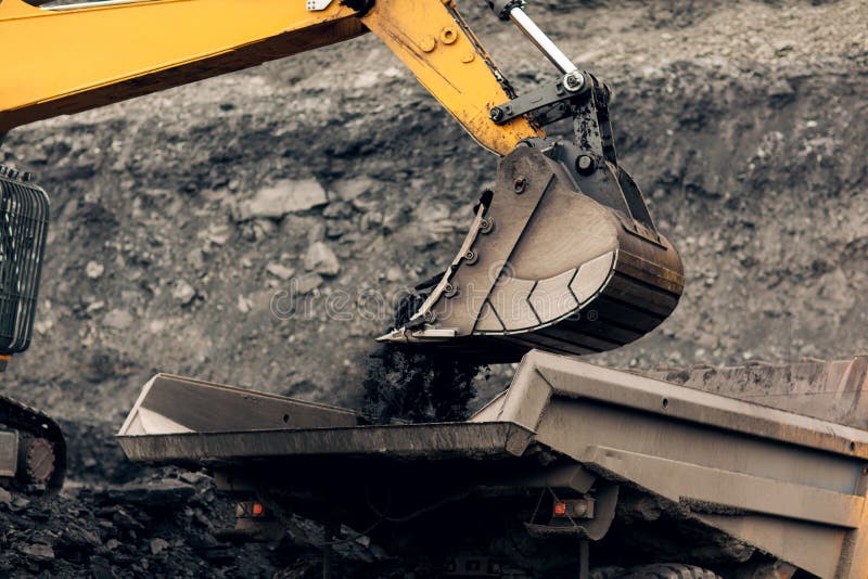 Excavator Loads Coal into the Back of a Heavy Mining Dump Truck. Stock ...