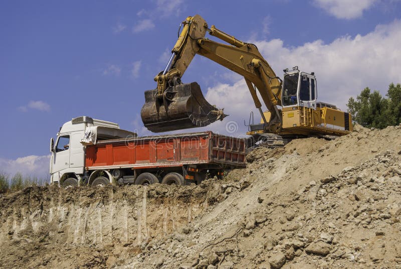 Excavator Loads Dump Truck Soil on the Construction Site Stock Image ...