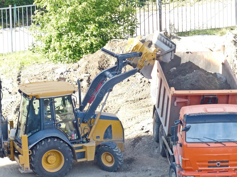 The Excavator Loads the Dump Truck with Soil. Loading Operations, Road ...