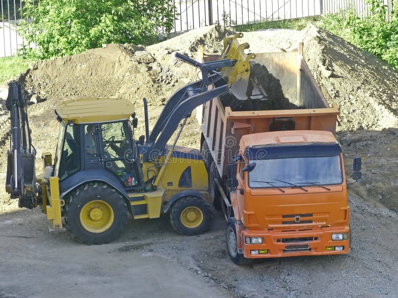 The Excavator Loads the Dump Truck with Soil. Loading Operations, Road ...