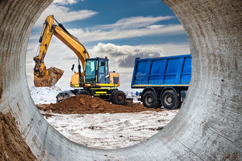 An Excavator Loads Soil or Sand into a Dump Truck. Pit Development ...