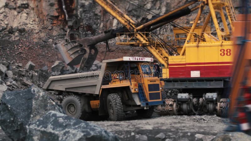 Excavator Loads a Stone in the Heavy Truck in the Quarry Mining Granite ...
