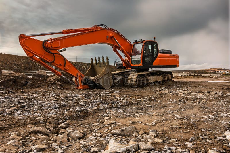 Excavator Moving Earth and Stone in the Construction Works of a Road ...