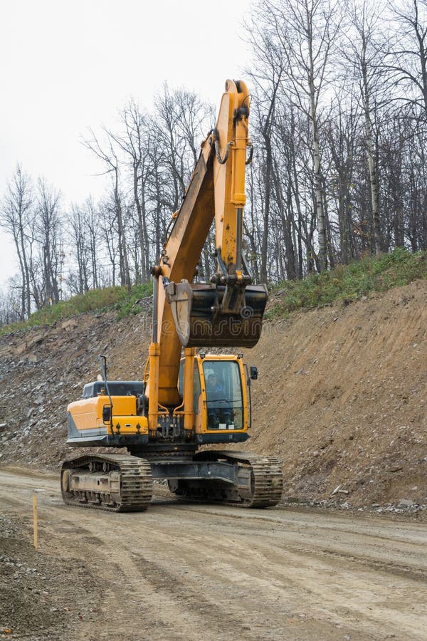 Excavator in operation editorial stock image. Image of road - 103299114