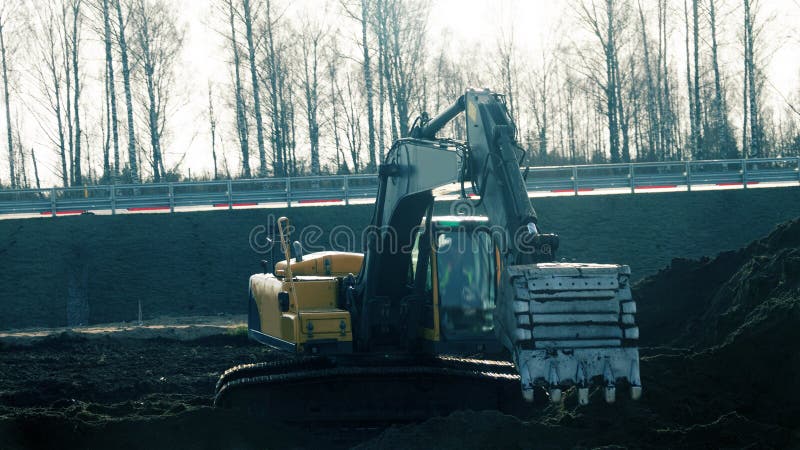 Excavator in the Process of Leveling the Slope of the Road Stock Photo ...