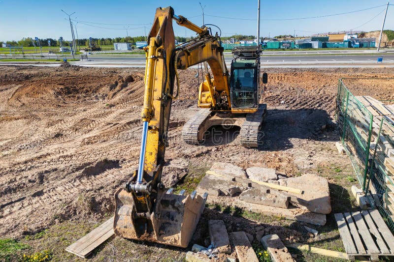 An Excavator Sits in the Middle of a Busy Construction Site, Surrounded ...