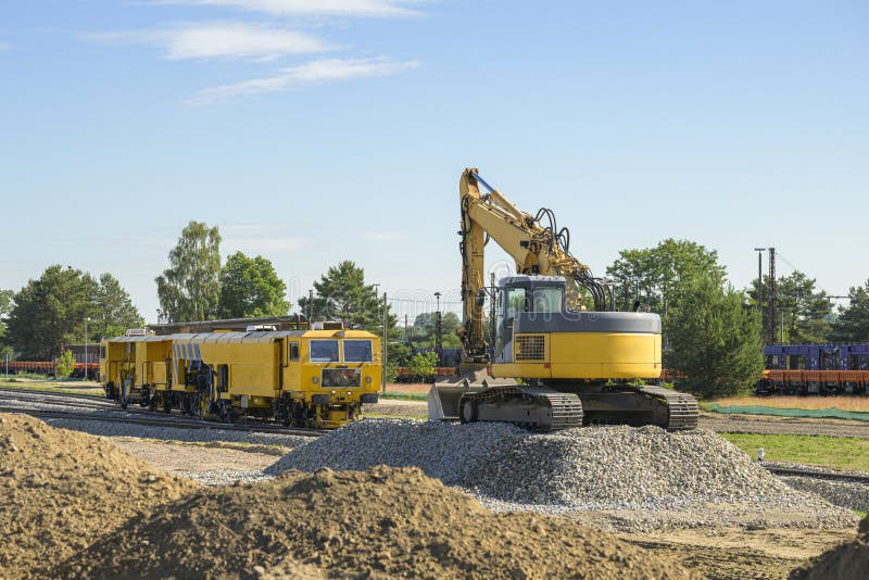 Excavator and Track Tamping Machine on a Construction Site Stock Photo ...