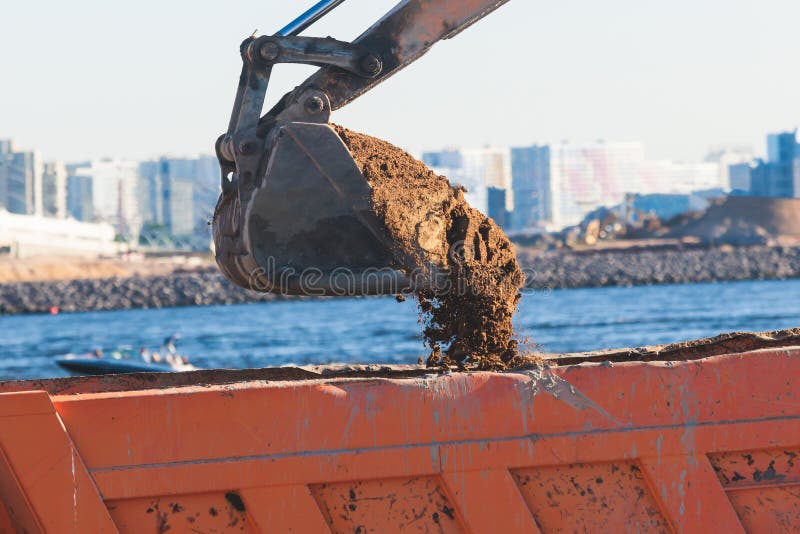 Excavator Unloading Sand into the Dump Truck on the Construction Site ...