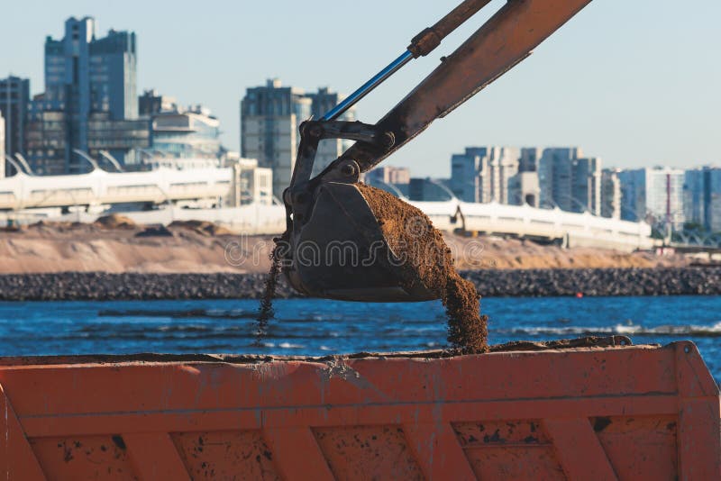 Excavator Unloading Sand into the Dump Truck on the Construction Site ...