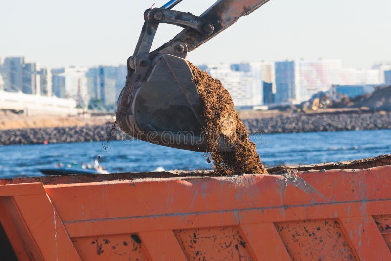 Excavator Unloading Sand into the Dump Truck on the Construction Site ...