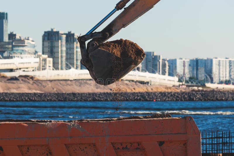 Excavator Unloading Sand into the Dump Truck on the Construction Site ...