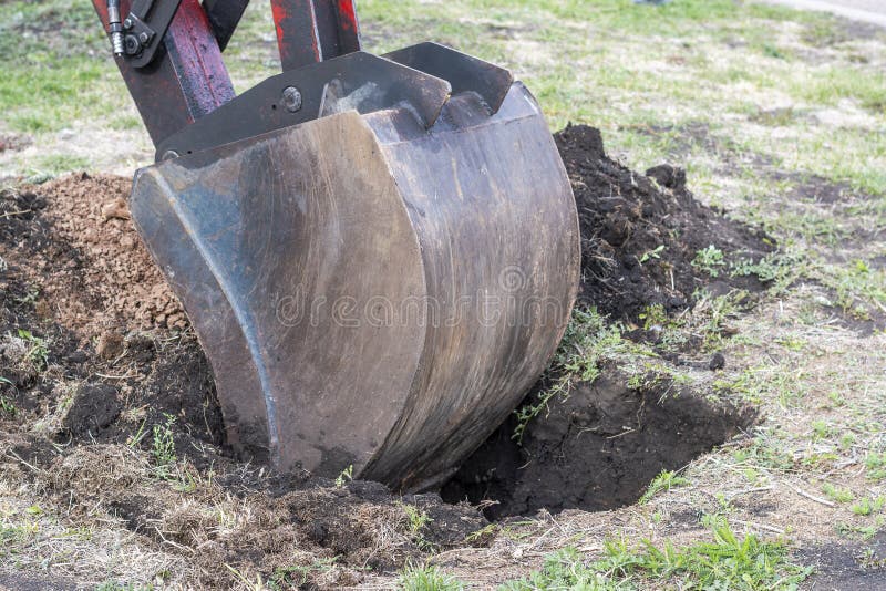 Excavator Work. the Iron Ladle Digs into the Ground. Digging a Hole ...