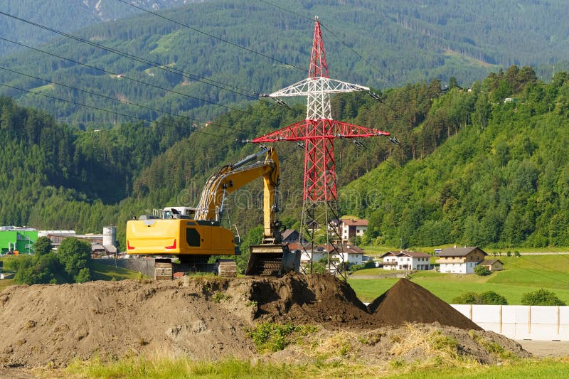 Excavator at Work Near Power Pylon in Mountainous Terrain Stock Image ...