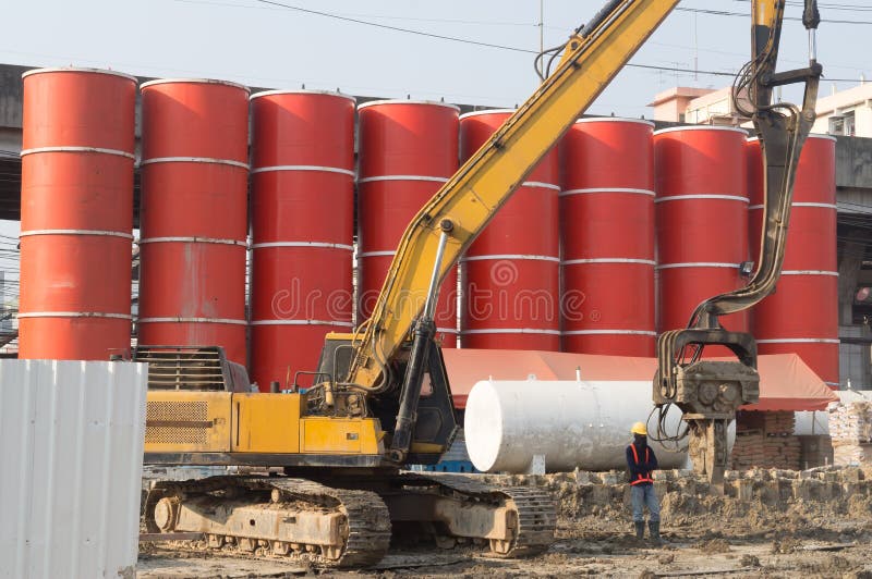 Excavator with Worker Working beside Red Drilling Solution Tanks at ...