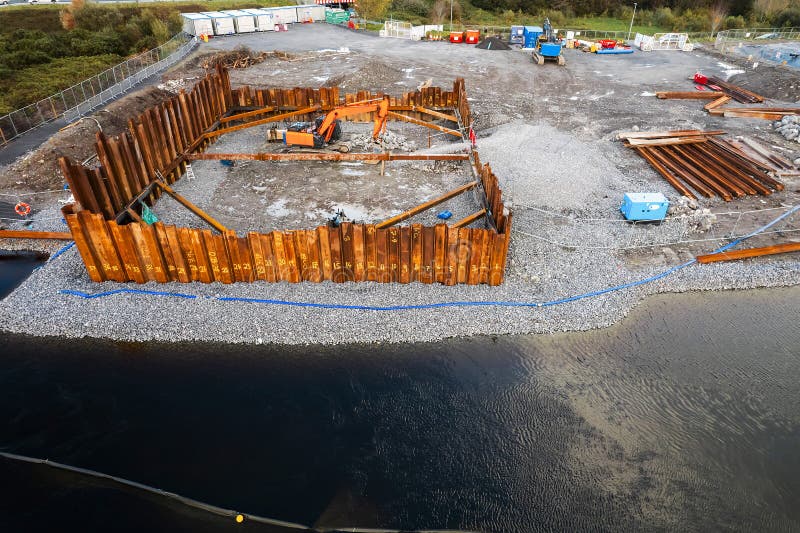 Excavator Working in Metal Frame Structure by a River. Construction ...
