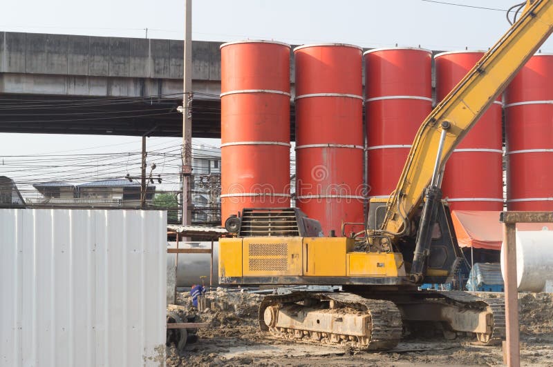 Excavator Working beside Red Drilling Solution Tanks at Construction ...
