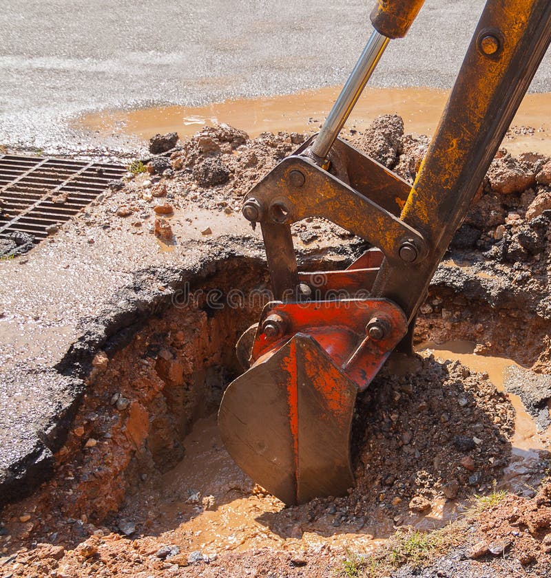 Excavator Working on the Repair of Pipe Water on Road Stock Photo ...