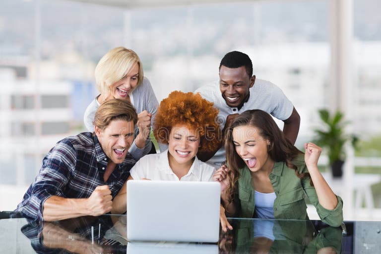 Excited Business People at a Desk Looking at a Computer Stock Photo ...