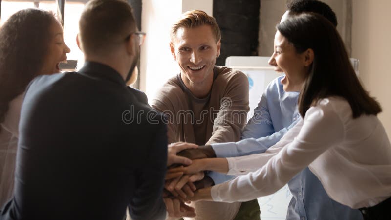 Excited Diverse Business People Stacking Hands at Corporate Meeting ... Excited Diverse Business People Stacking Hands at Corporate Meeting ...