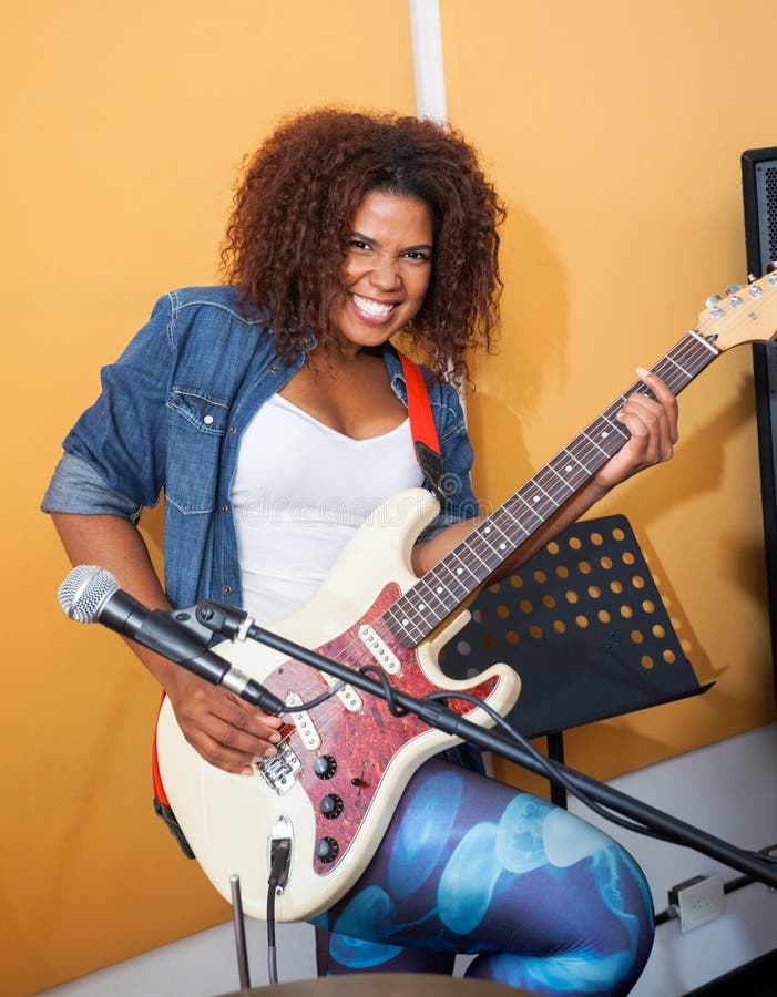 Excited Female Playing Guitar in Recording Studio Stock Image - Image ...