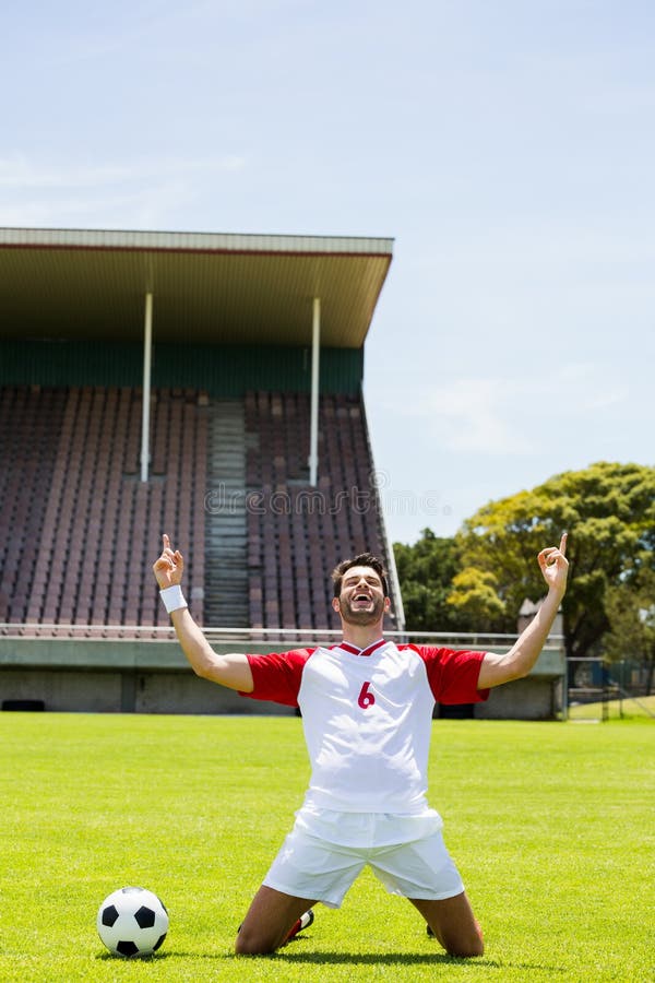 Excited Football Player Kneeling in Stadium Stock Photo - Image of ...