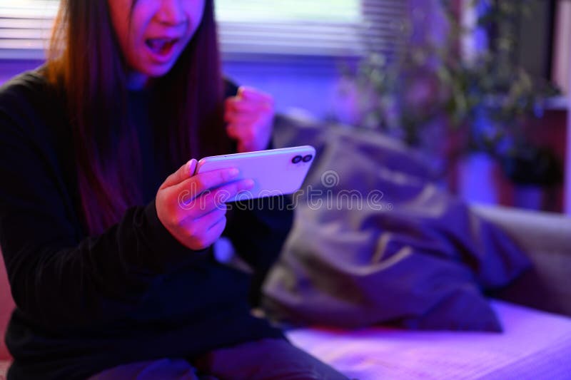 Excited Gamer Celebrates Win in a Mobile Game Under Vibrant LED ...