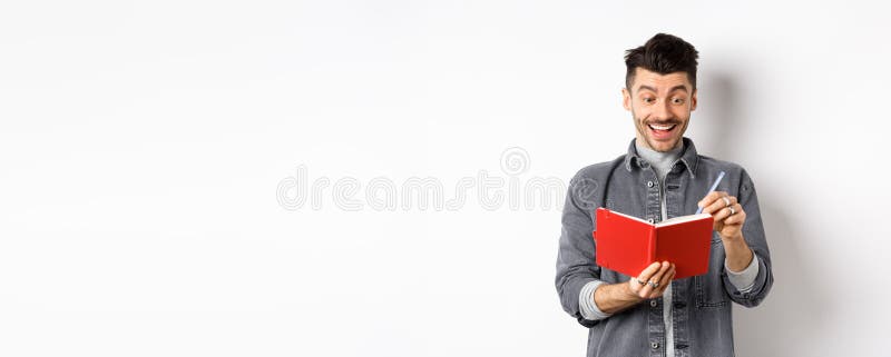 Excited Guy Writing in Planner and Smiling, Writing Down Ideas in ...