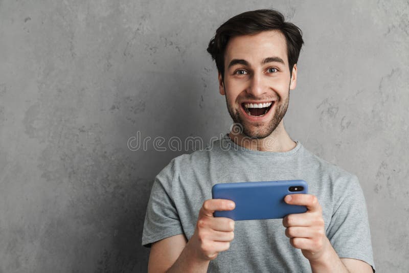 Excited Handsome Guy Laughing and Using Mobile Phone Stock Photo ...