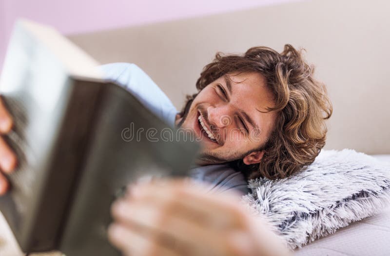 Excited Man Reading Book in Bed Stock Photo - Image of bedroom, indoor ...