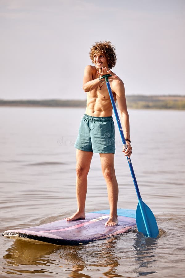 Excited Man Standing On Surfboard In River Concentrated Man During