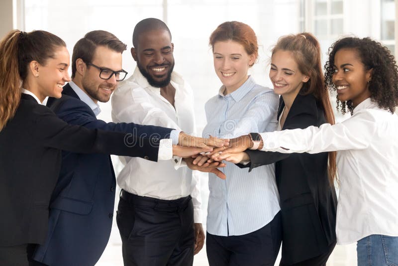 Excited Multiethnic Employees Stack Hands Showing Support and Unity ...