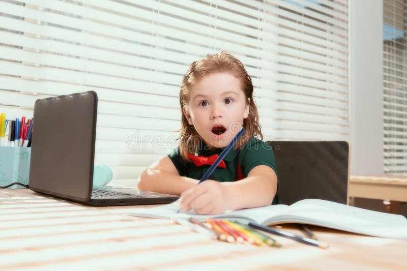 Excited School Boy Writing at Notebook in Classroom at the Elementary ...