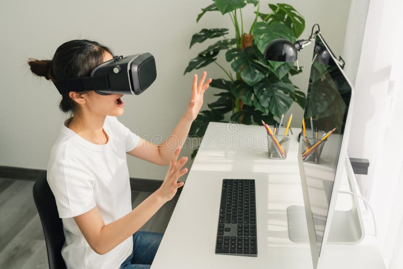 Excited Young Asian Woman Using a Virtual Reality Headset and Joysticks ...