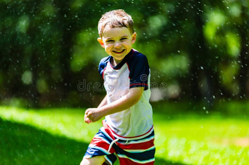 Excited Young Boy Running through the Sprinkler Stock Image - Image of spraying, enjoy: 309452157