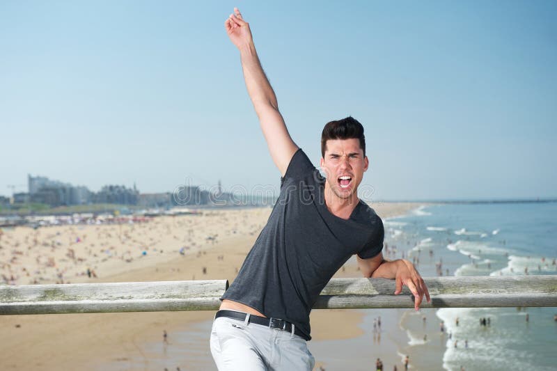 Excited Young Man with Hand Raised at the Beach Stock Image - Image of ...
